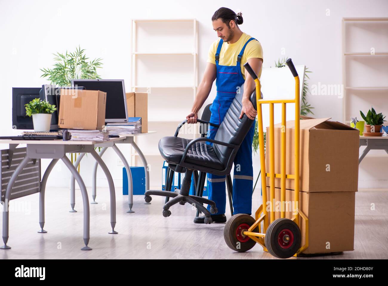 Young male contractor in moving concept Stock Photo - Alamy