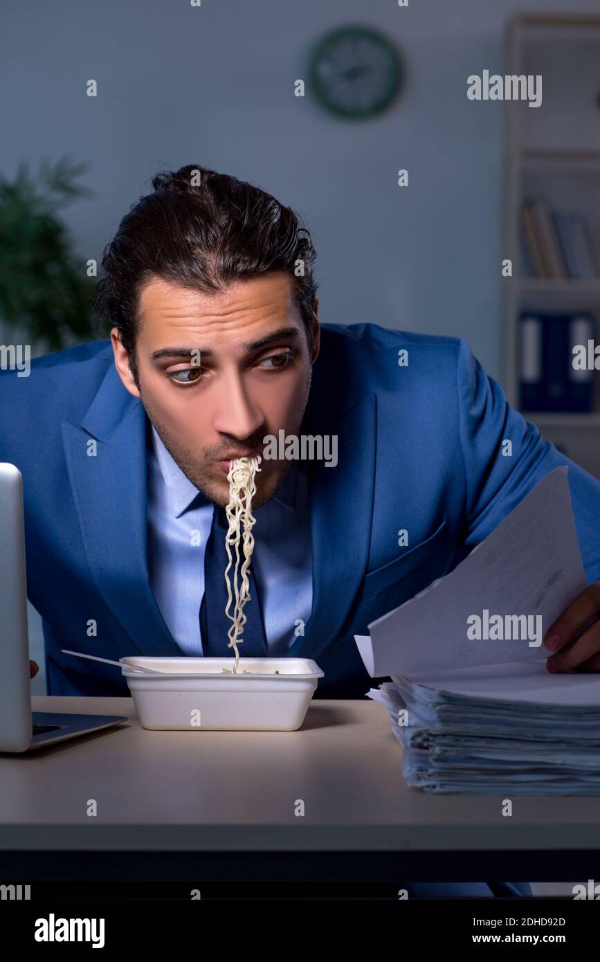 Hungry employee working late in the office Stock Photo - Alamy