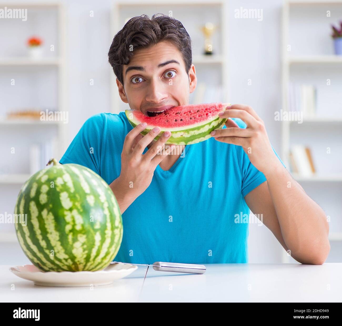 Man eating watermelon at home Stock Photo - Alamy