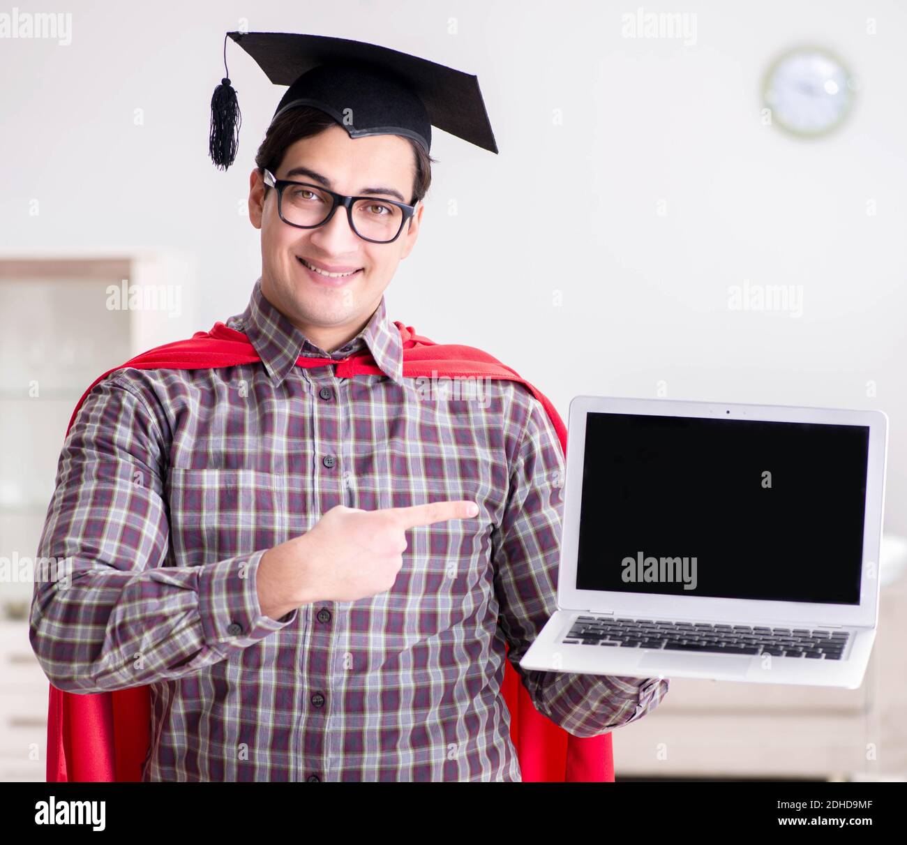 Super hero student wearing mortarboard and holding a laptop Stock Photo ...