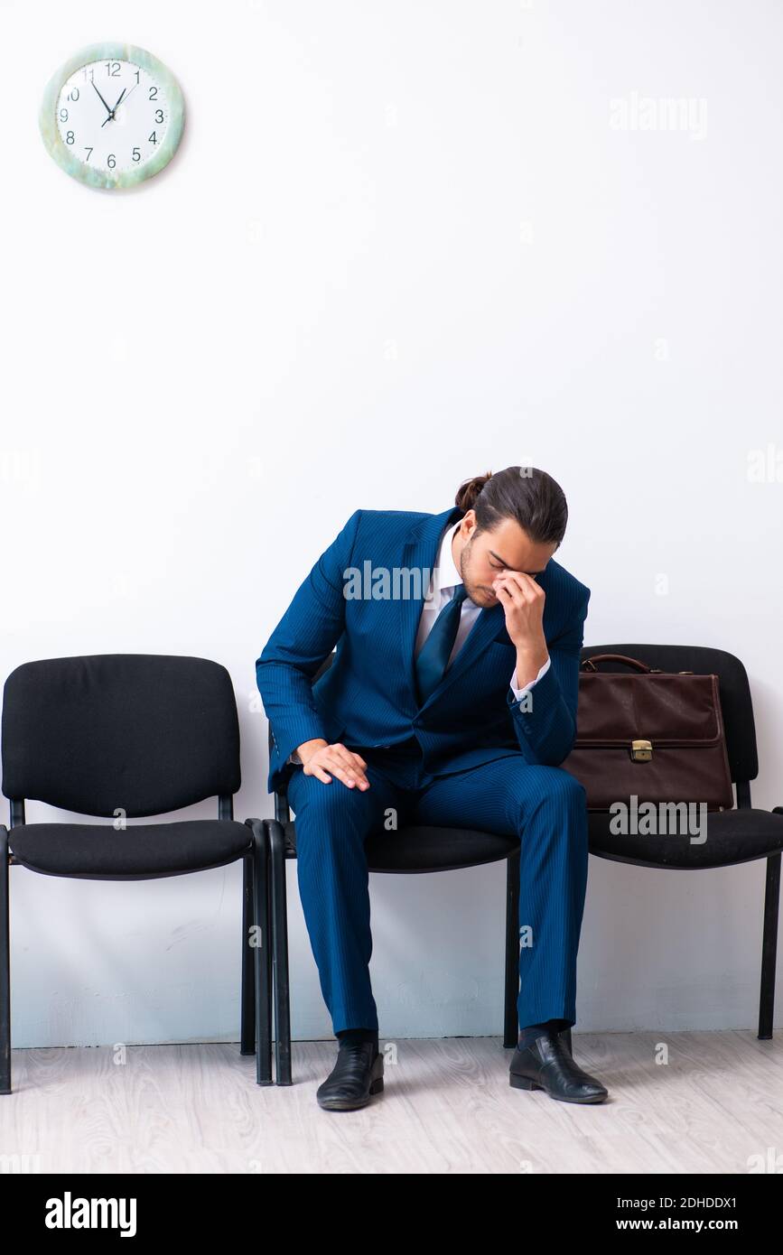 Young businessman waiting for an interview at hall Stock Photo - Alamy