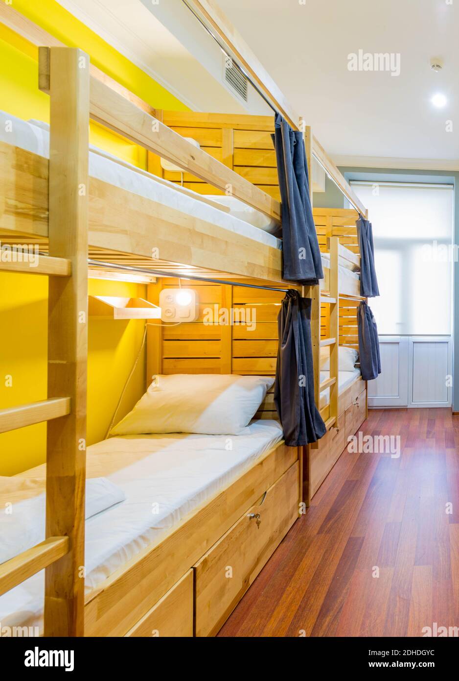Hostel dormitory beds arranged in room Stock Photo - Alamy