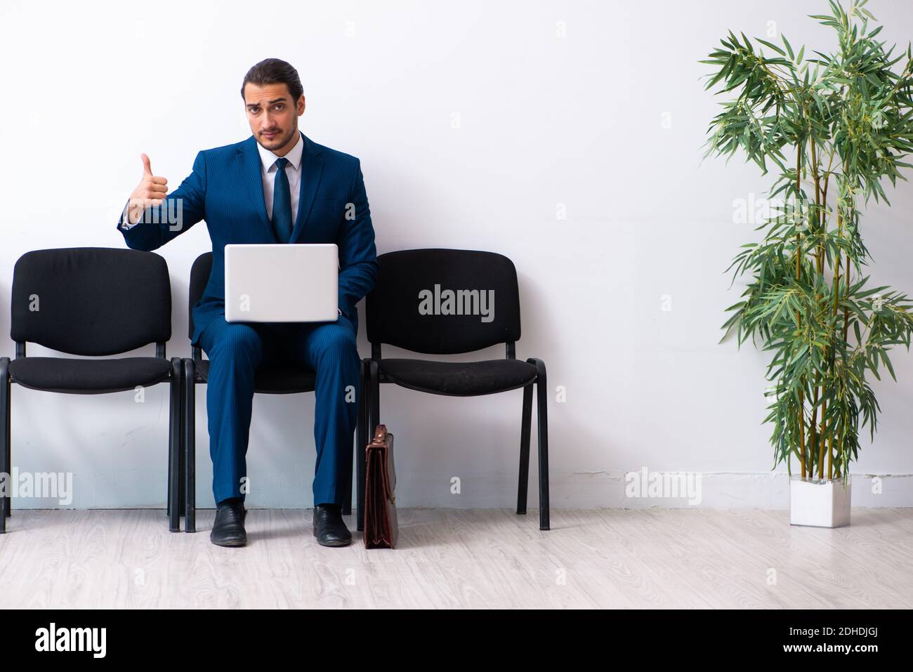 Young businessman waiting for an interview at hall Stock Photo - Alamy