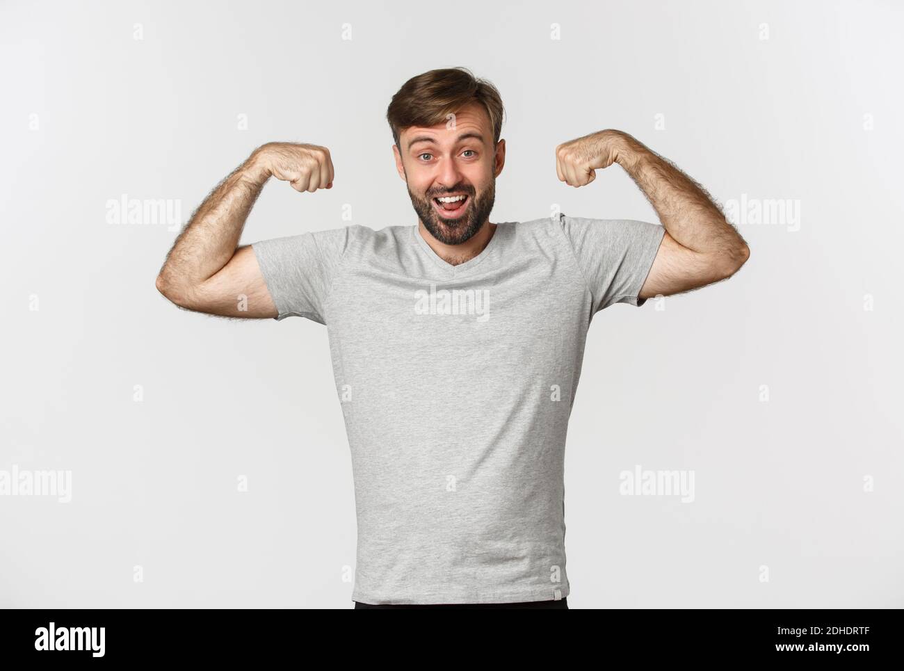 Portrait of confident bearded man flexing biceps, showing his muscles ...
