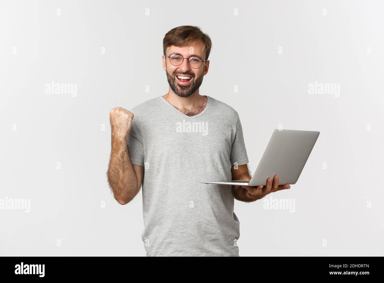 Portrait of cheerful handsome guy in glasses and gray t-shirt, holding ...