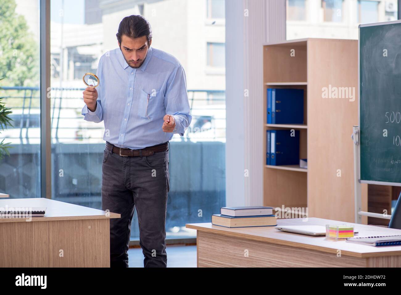 Young male teacher in the classroom Stock Photo - Alamy