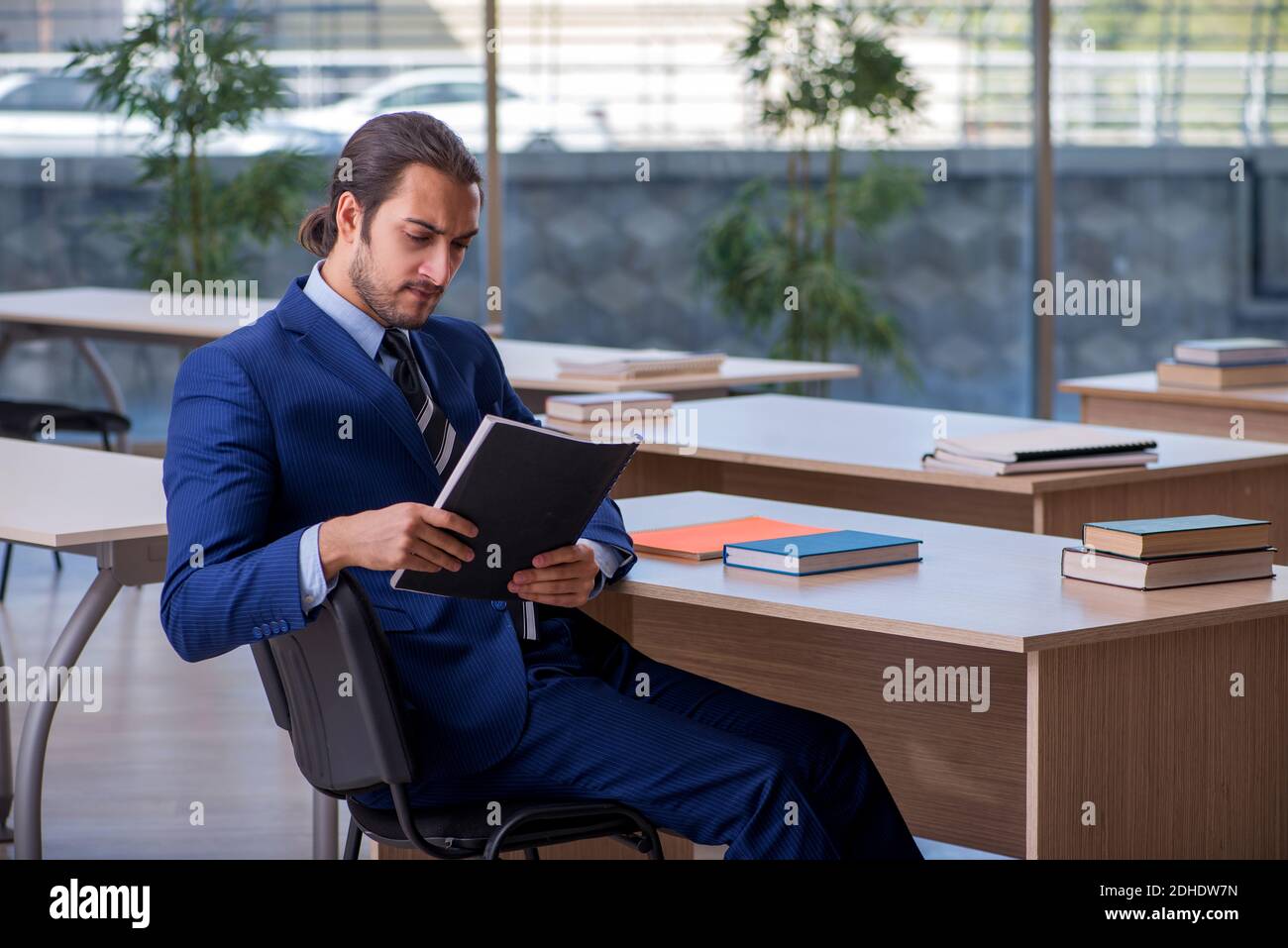 Young male teacher in suit in the classroom Stock Photo - Alamy
