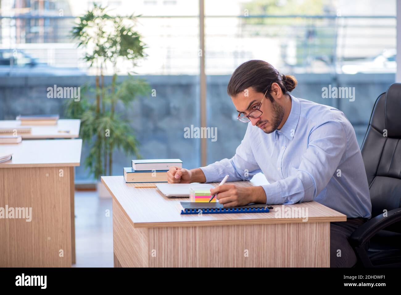 Young male teacher in the classroom Stock Photo - Alamy