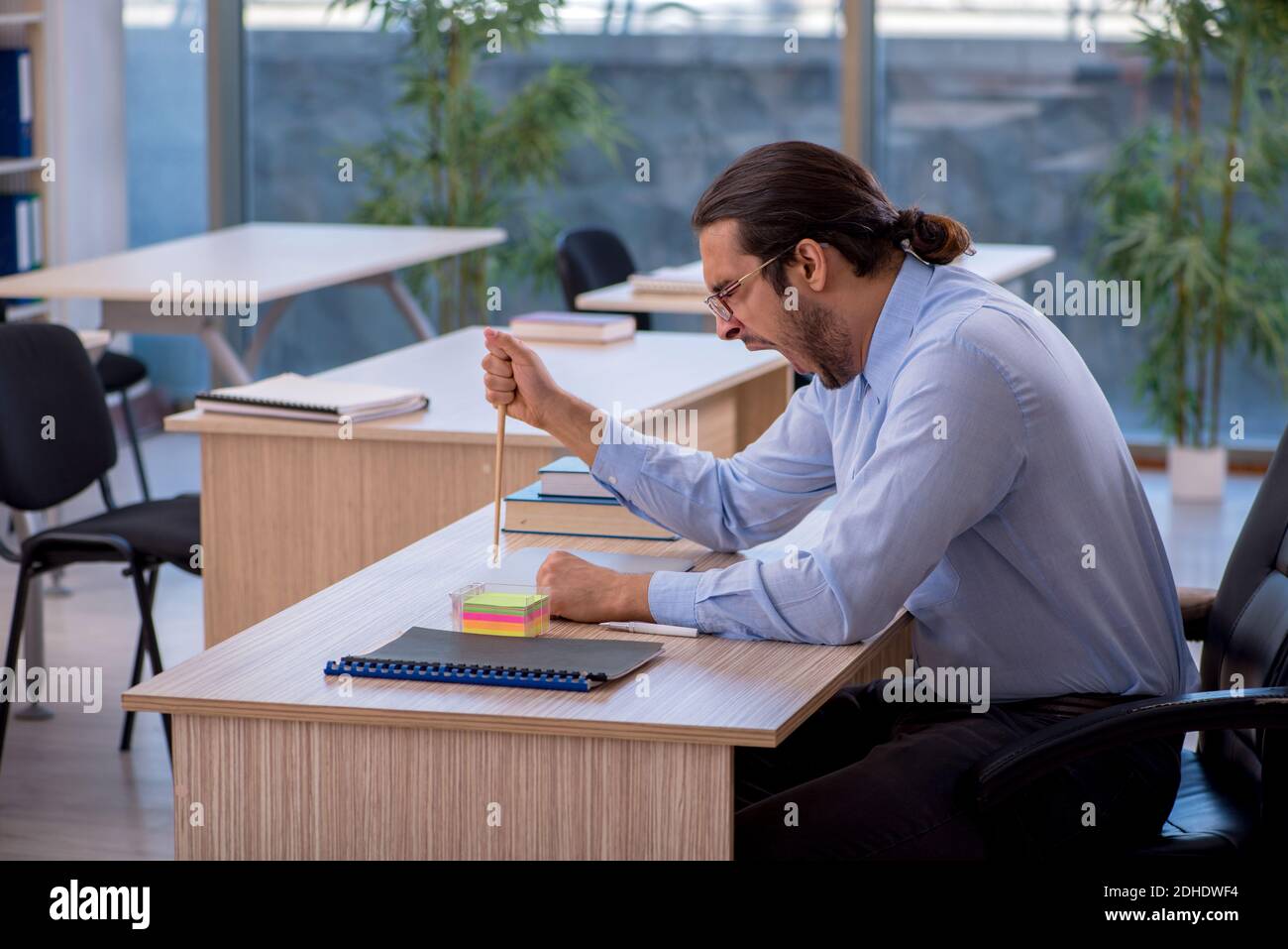 Young male teacher in the classroom Stock Photo - Alamy