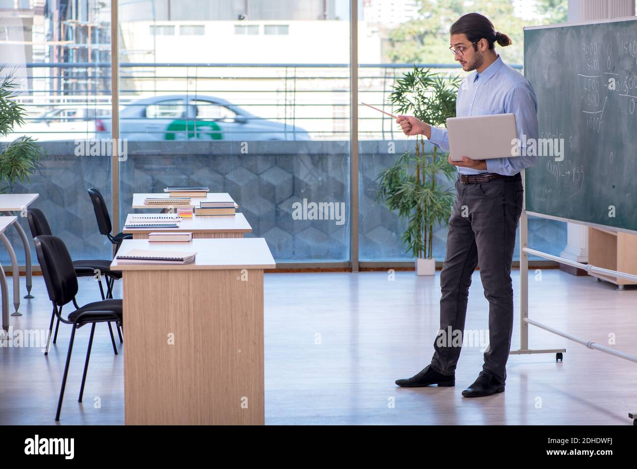 Young male teacher in the classroom Stock Photo - Alamy