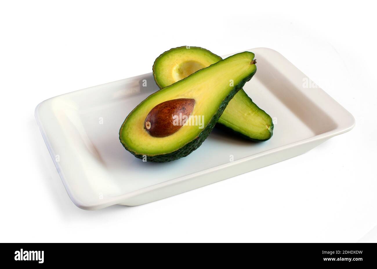 fresh avocado cut in half on square plate Stock Photo - Alamy