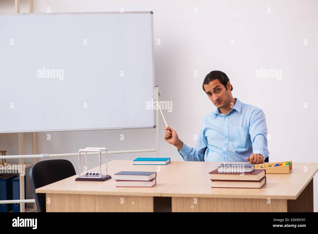 Young male teacher in the classroom Stock Photo - Alamy