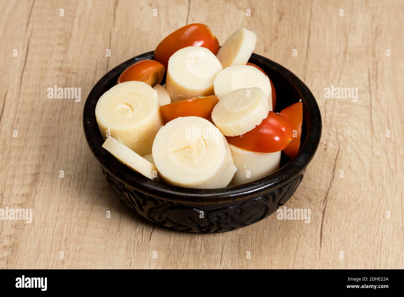 Simple and fresh palm heart or palmito salad in a black bowl on a ...