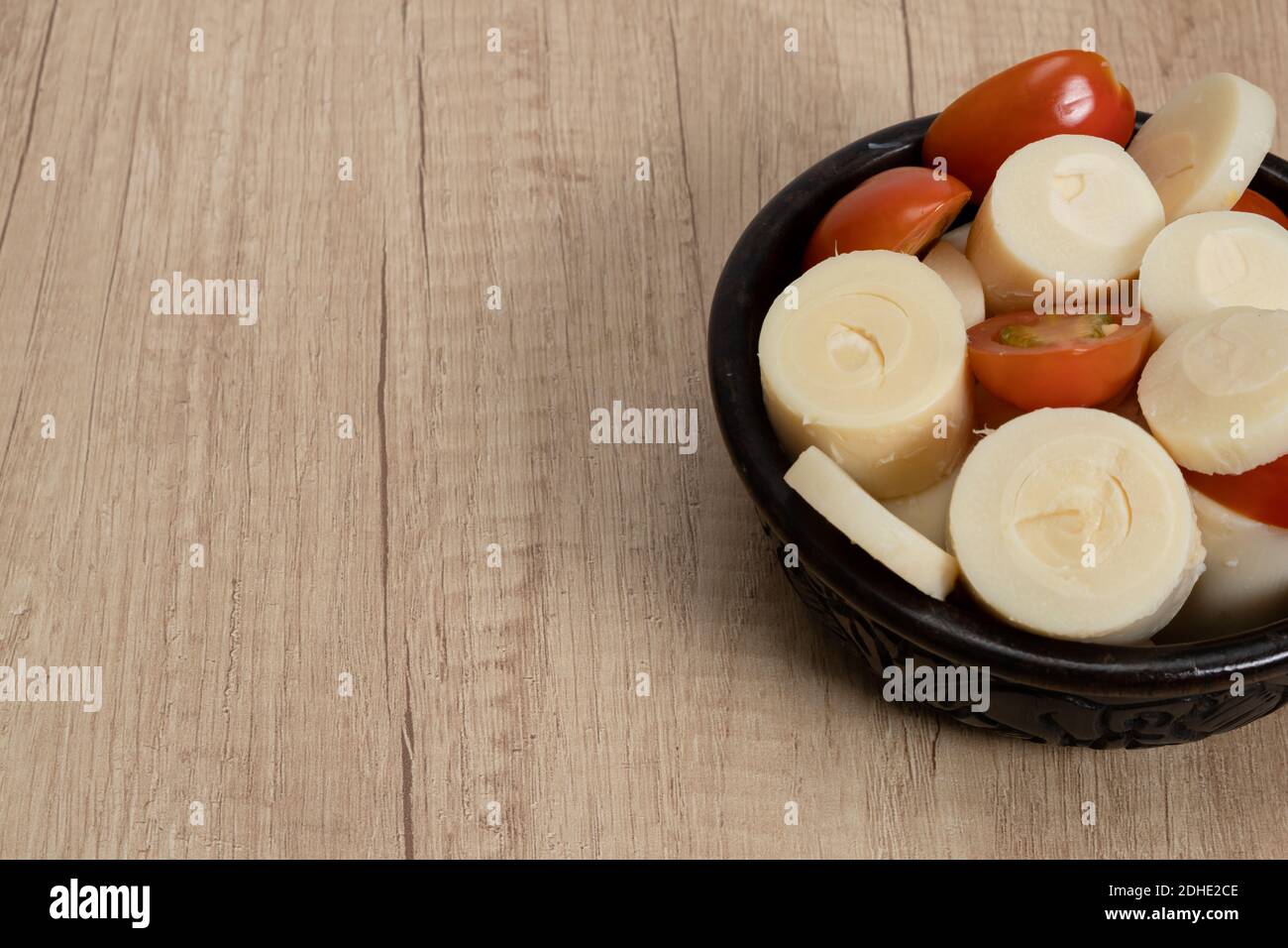 Simple and fresh palm heart or palmito salad in a black bowl on a ...