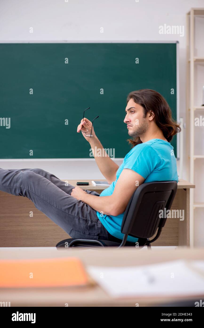 Young male student in front of green board Stock Photo - Alamy