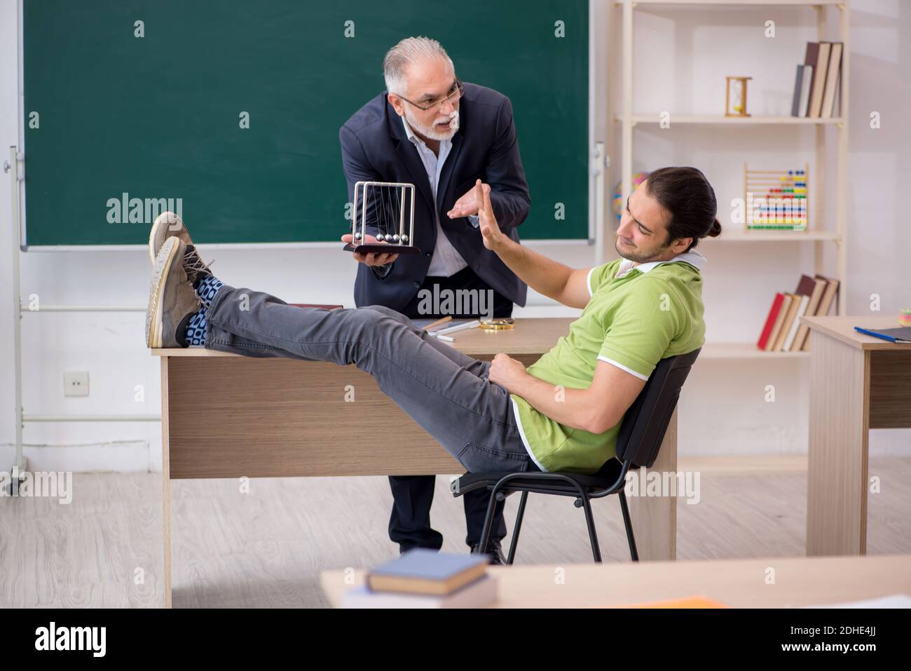 Aged physics teacher and male student in the classroom Stock Photo - Alamy