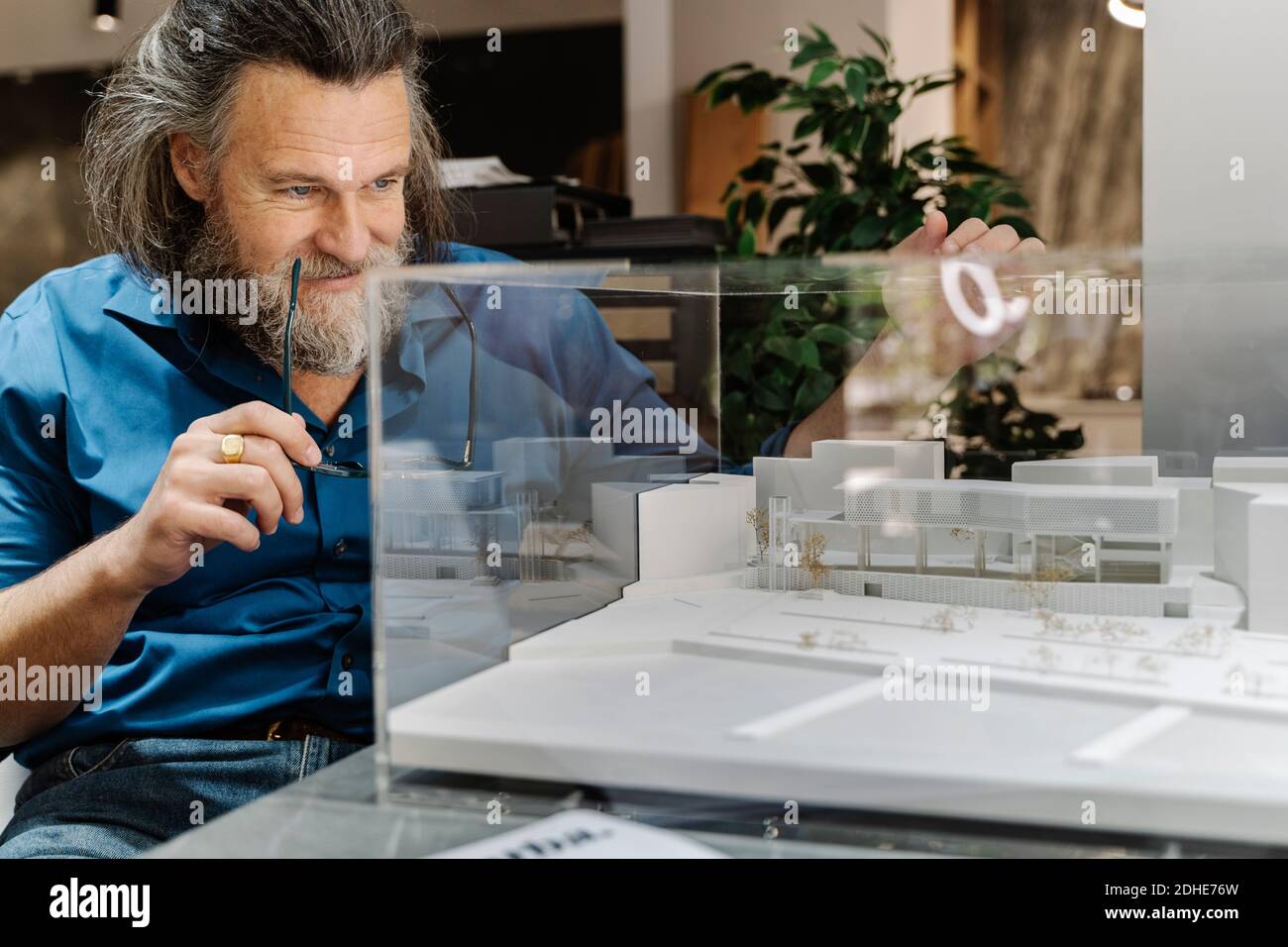 Mature man with a beard observing a model of a construction ...