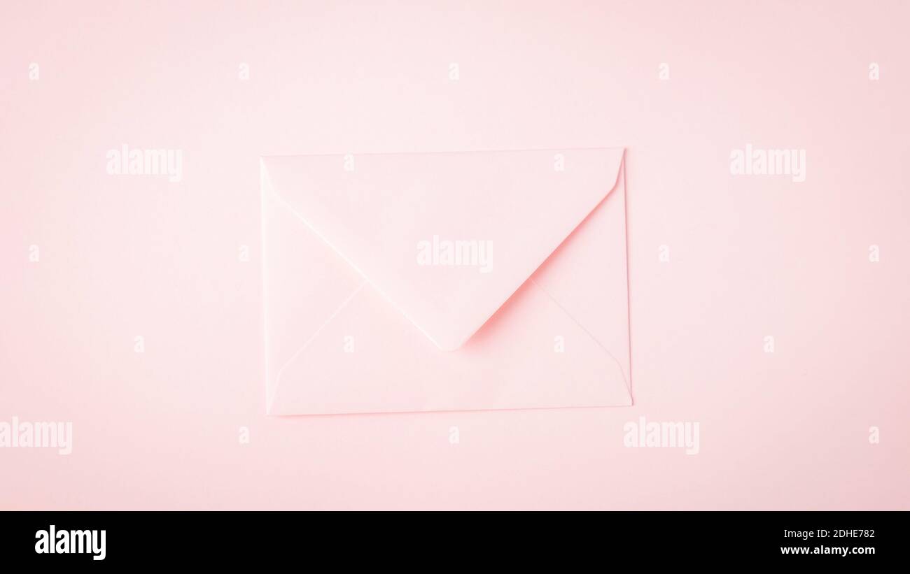 Light pink envelope on pink background. Delicate panorama background ...