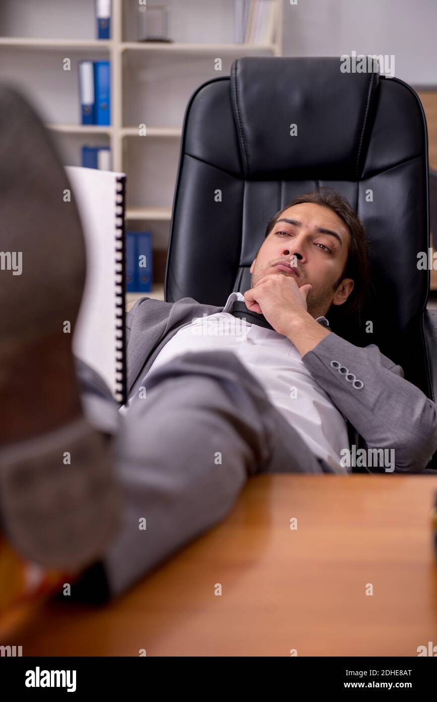 Young male employee sleeping at workplace Stock Photo - Alamy