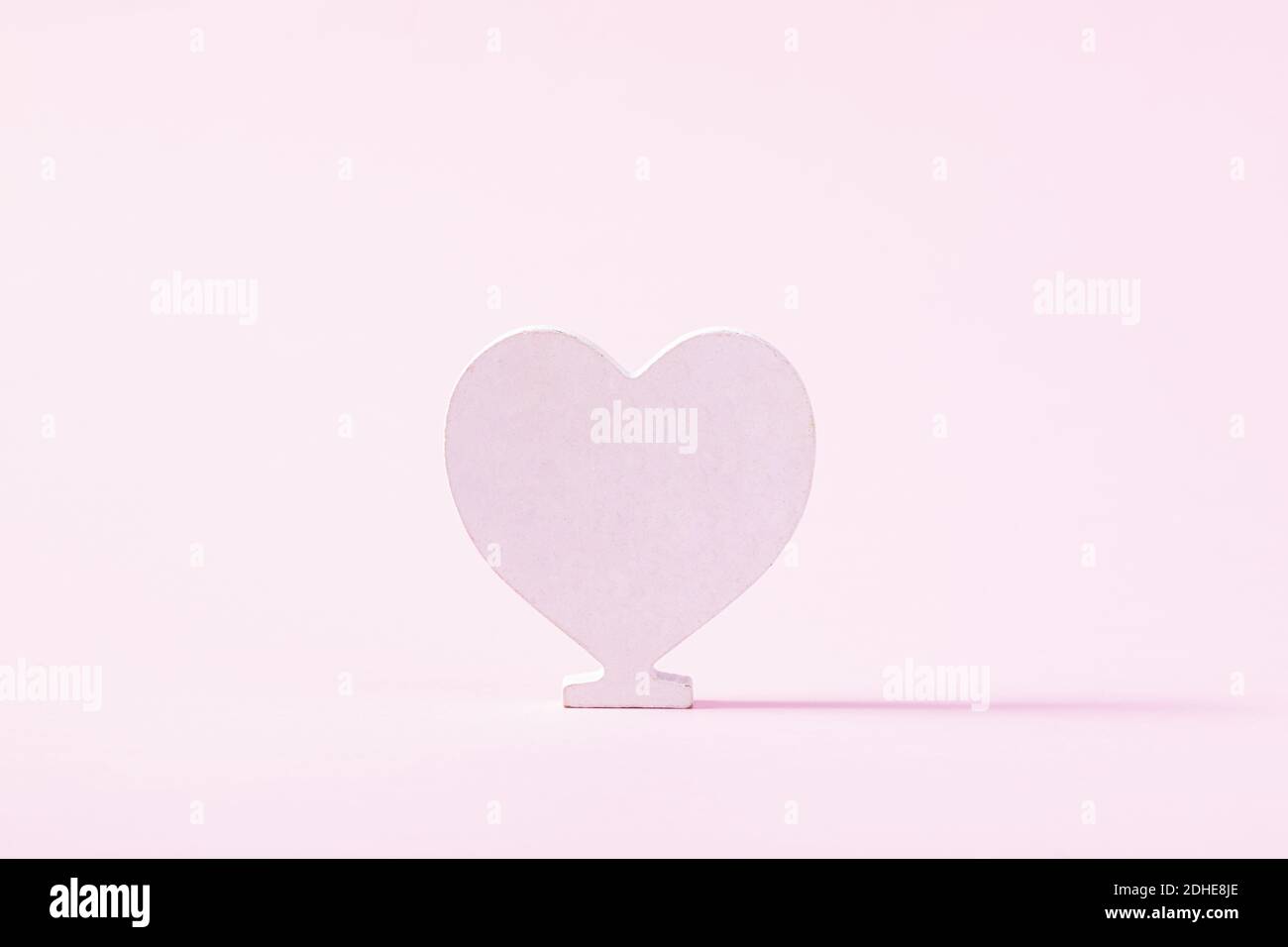 A big light pink heart-shaped figurine on the light background, a Saint ...