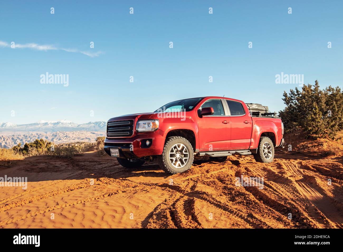 red overlanding pickup truck with tent in soft sand near Moab Utah ...