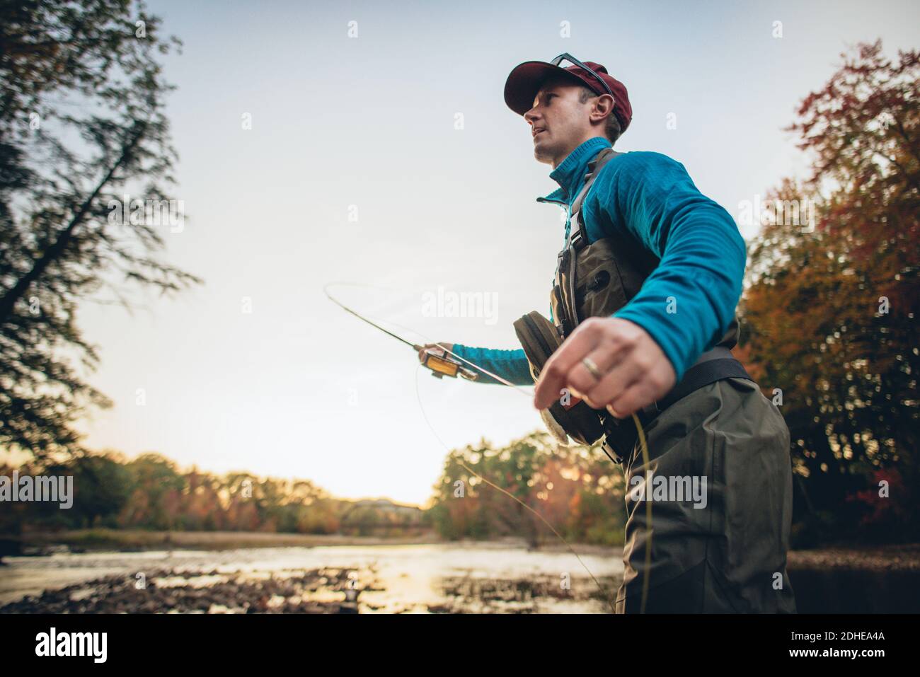 Wide-angle of man casting while fly-fishing at sunset Stock Photo - Alamy