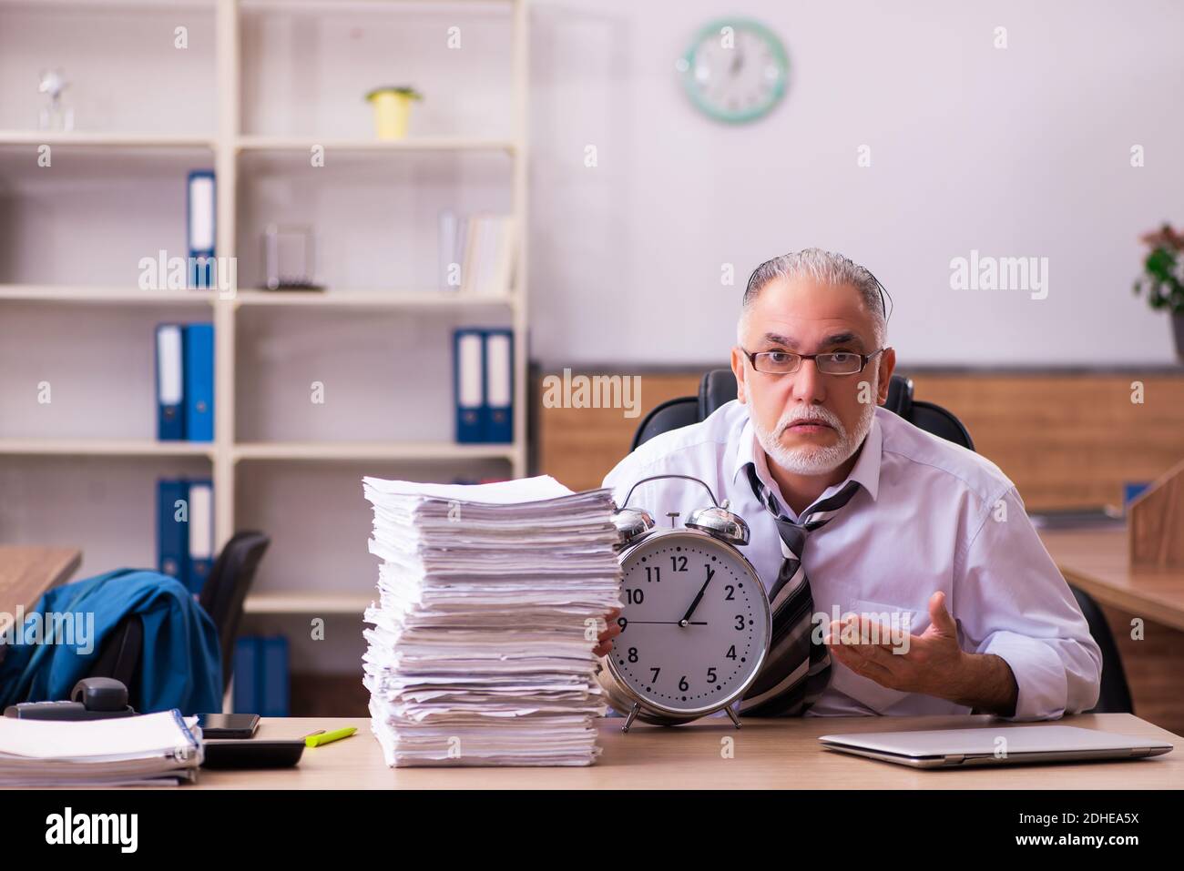 Old male employee unhappy with excessive work in the office Stock Photo ...