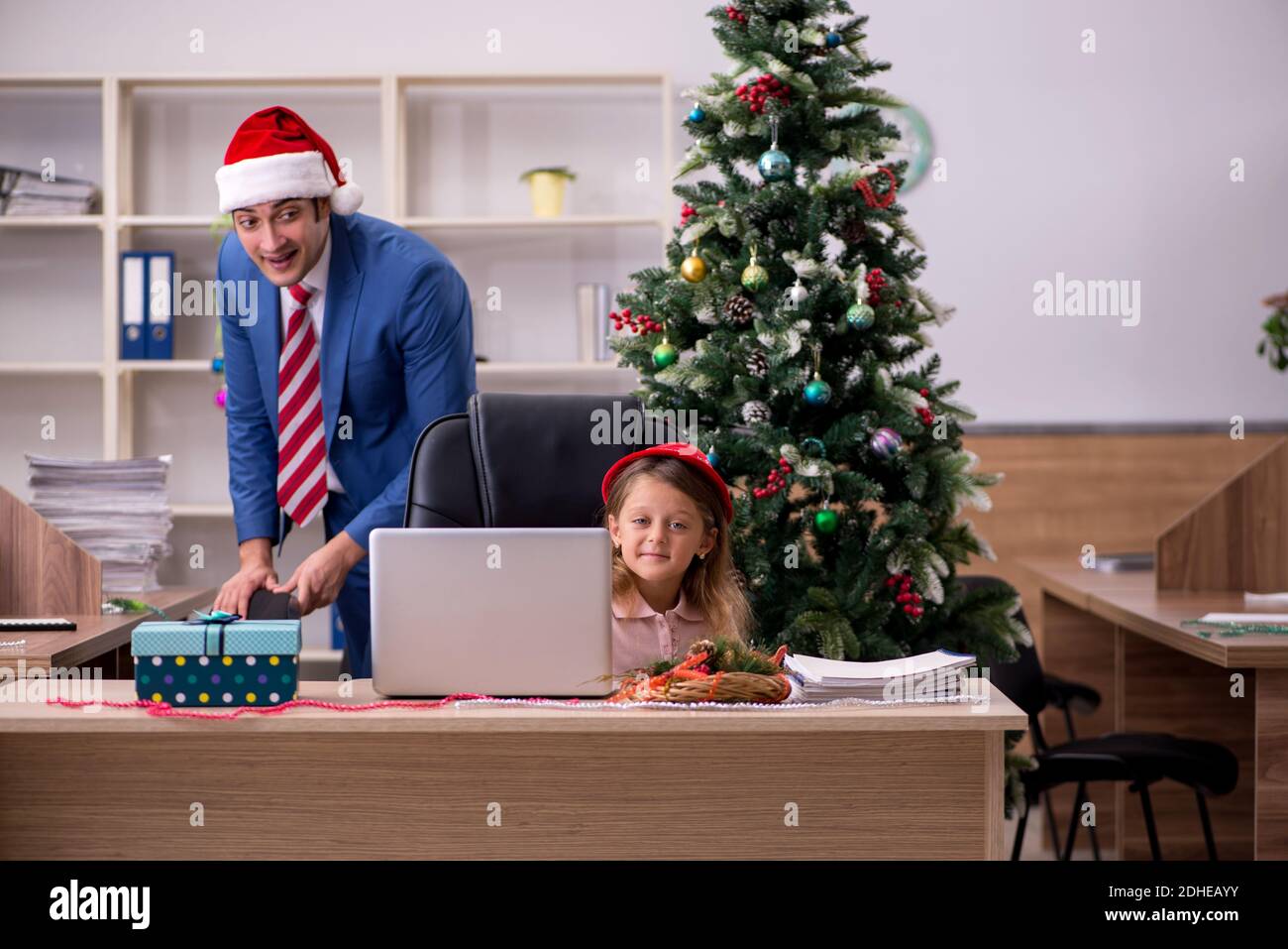 Young male employee celebrating Christmas at workplace with his Stock ...