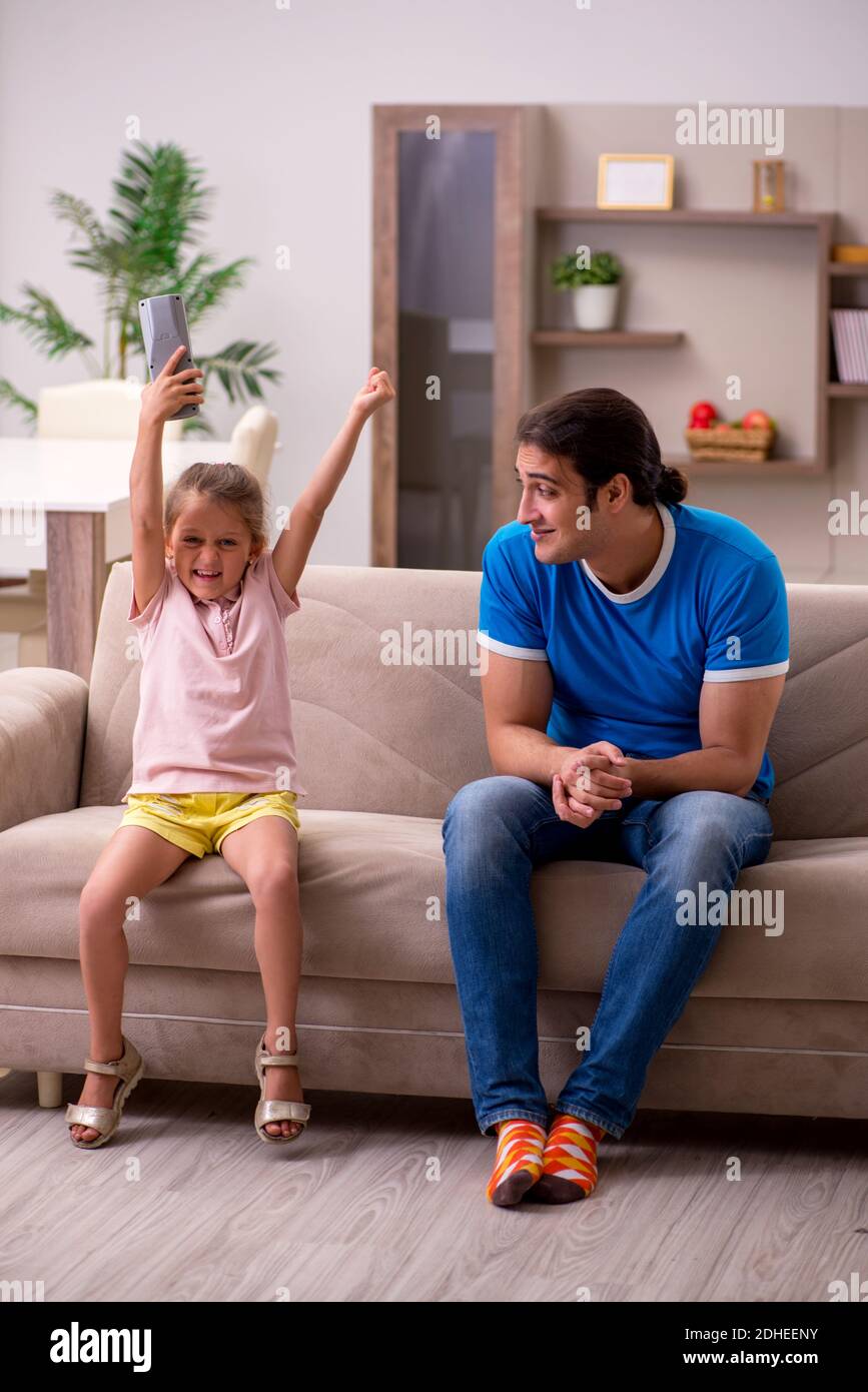 Young man with his daughter at home Stock Photo - Alamy