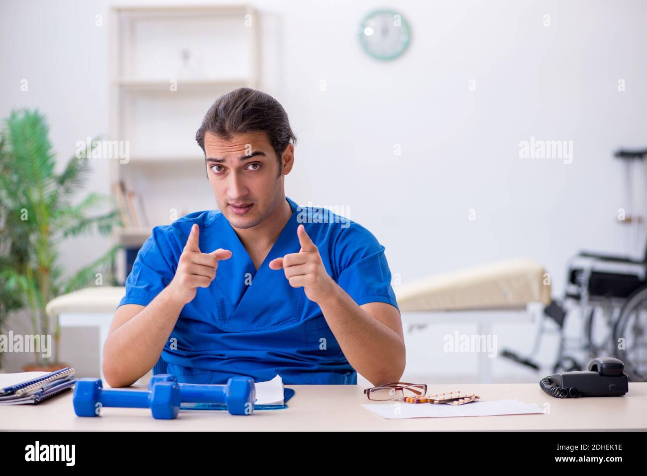 Young male doctor physiotherapist doing sport exercises Stock Photo - Alamy