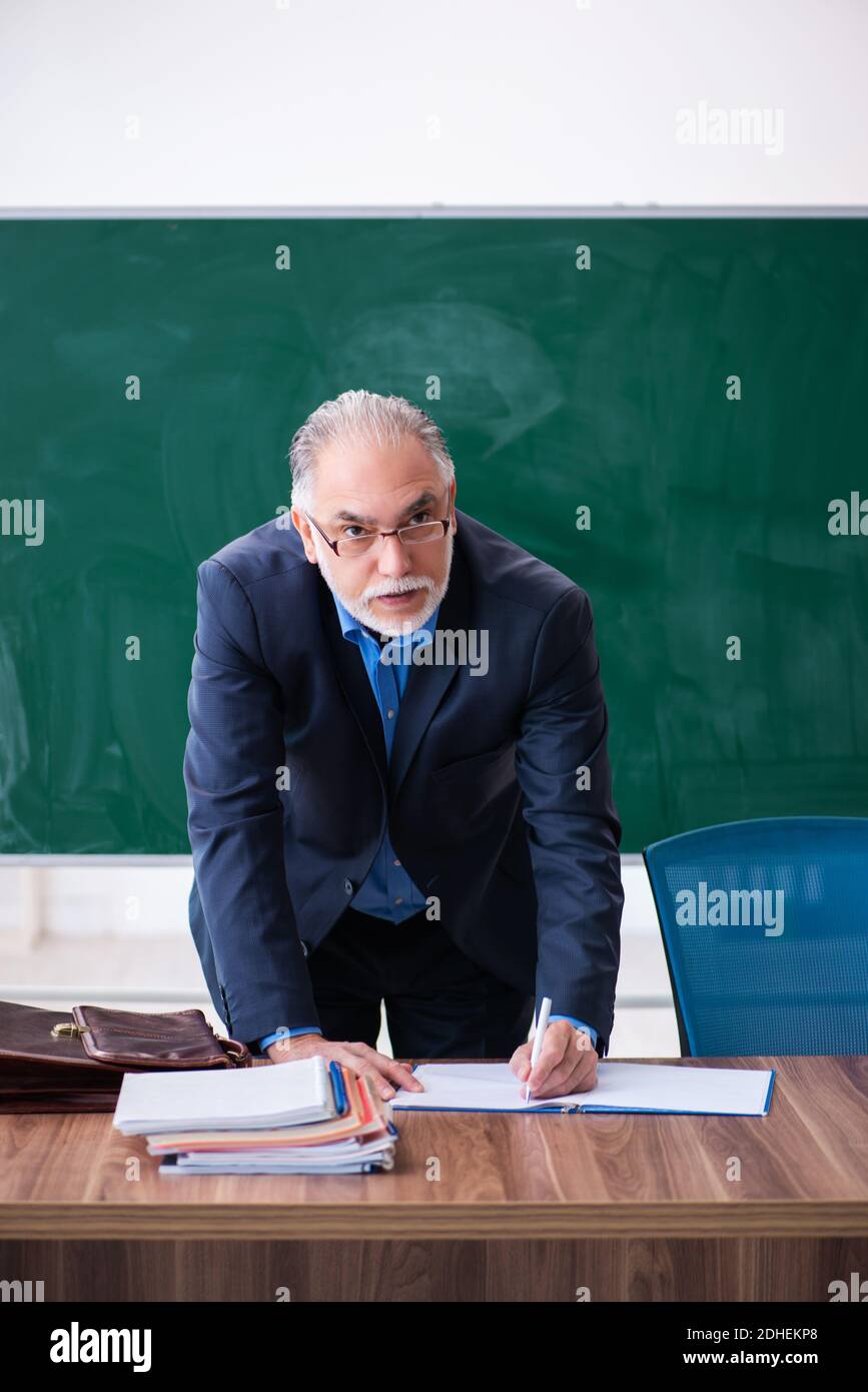 Old male math teacher in the classroom Stock Photo - Alamy