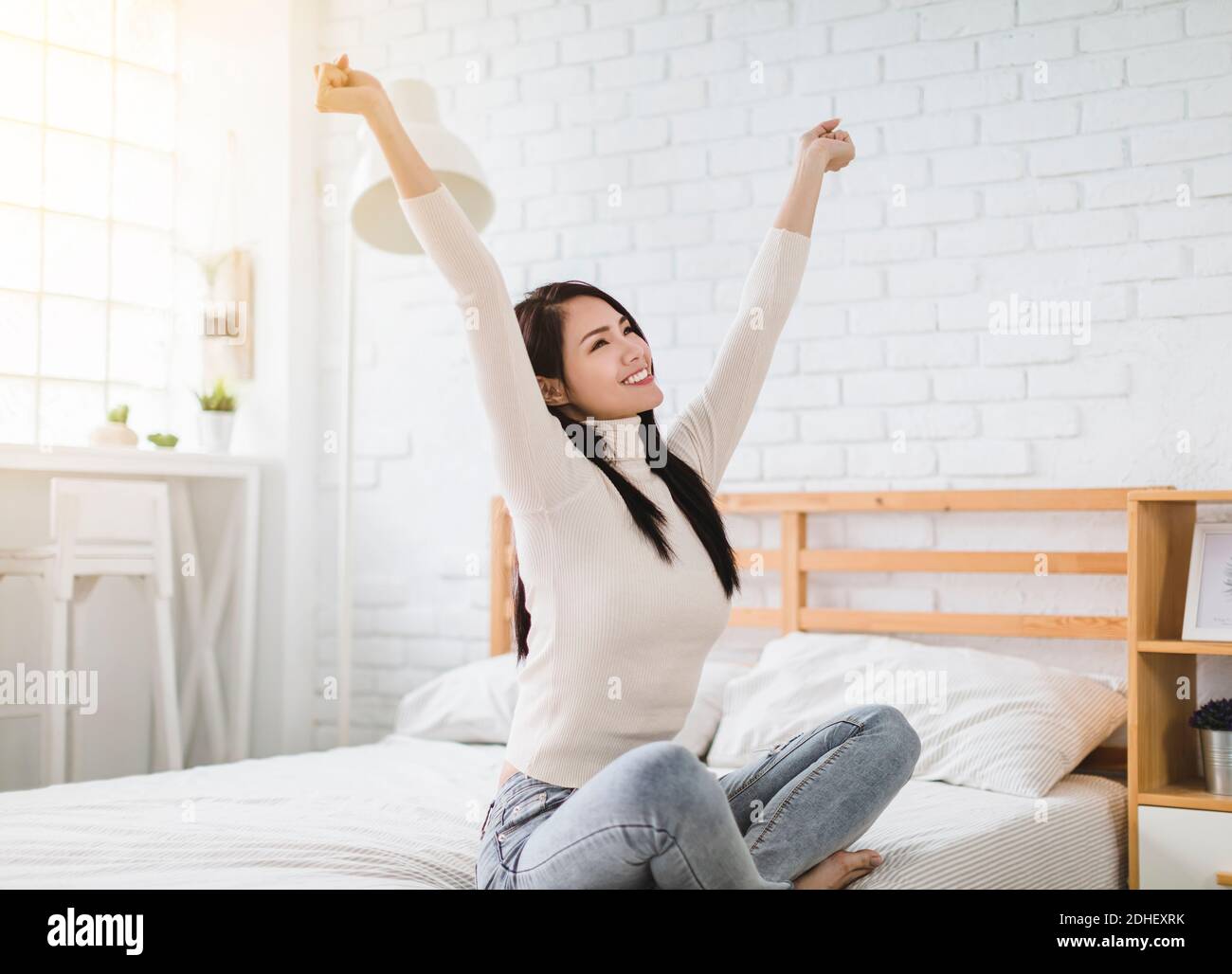Beautiful Young Woman Stretching And Waking Up In The Bedroom Stock