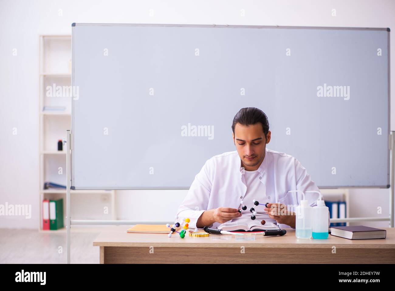 Young male chemistry teacher in the classroom Stock Photo - Alamy