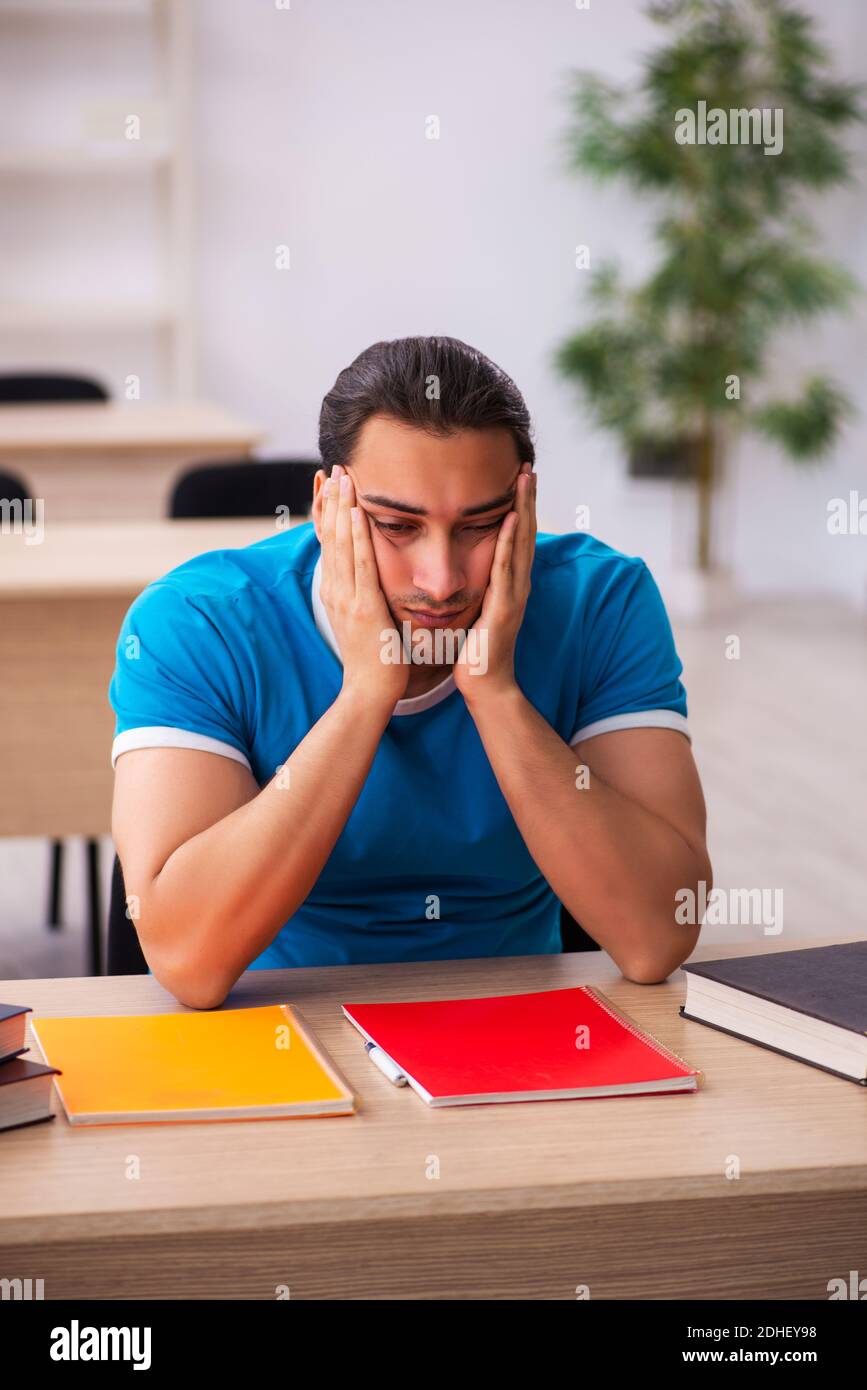 Exhausted male student preparing for the exams in the classroom Stock ...