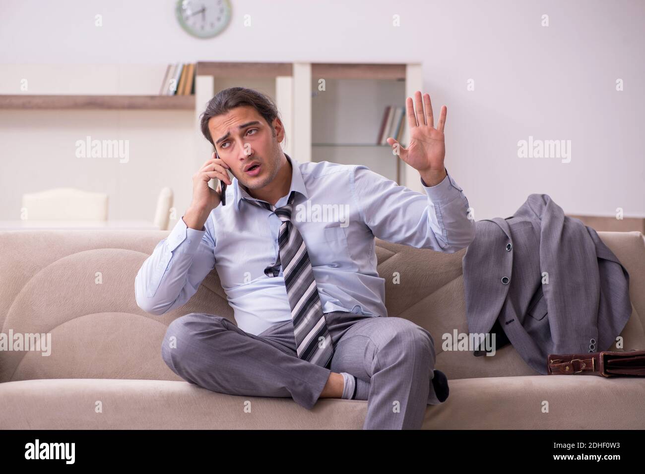 Tired young businessman coming home after working day Stock Photo - Alamy