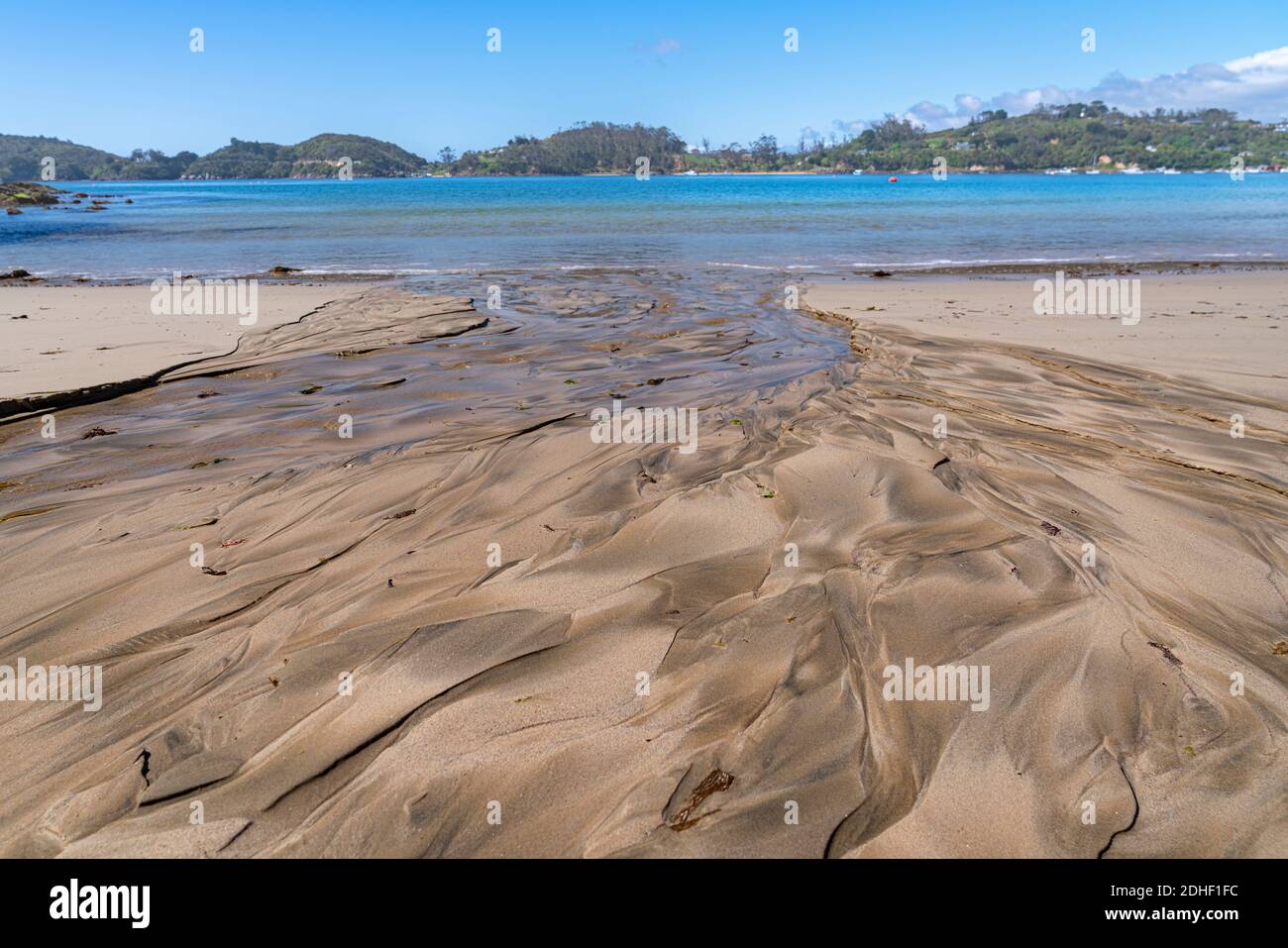 Patterns in created by water from small stream washing across beach to ...