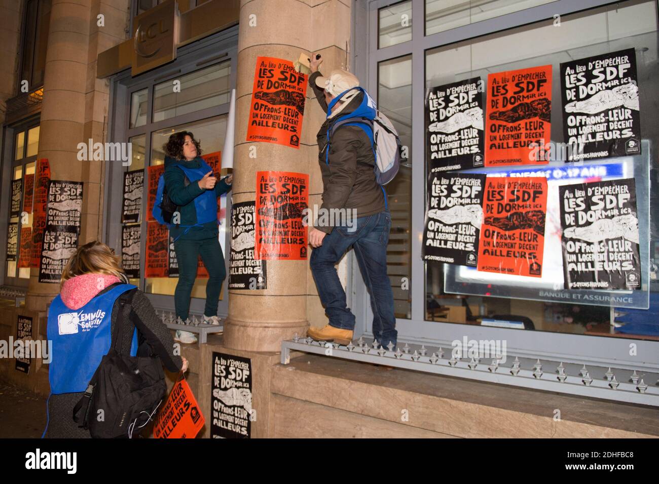 Activists from the Fondation Abbe Pierre foundation stick leaflets and ...