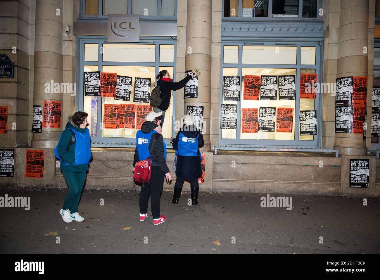 Activists from the Fondation Abbe Pierre foundation stick leaflets and ...