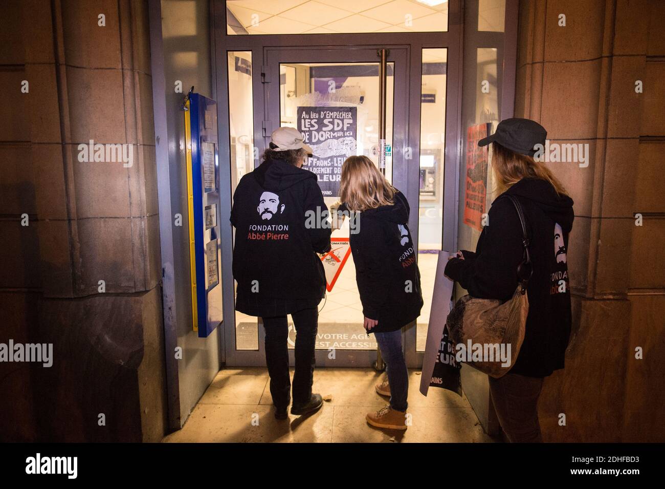 Activists from the Fondation Abbe Pierre foundation stick leaflets and ...