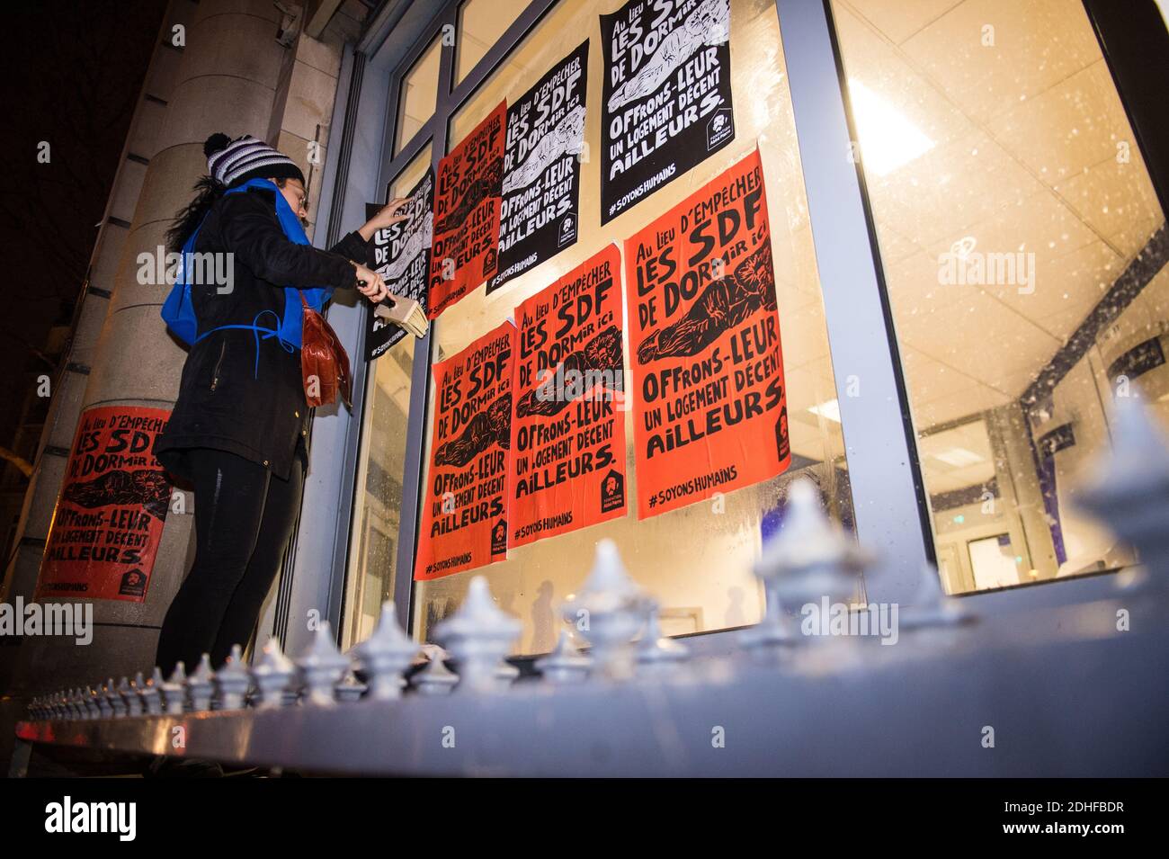 Activists from the Fondation Abbe Pierre foundation stick leaflets and ...