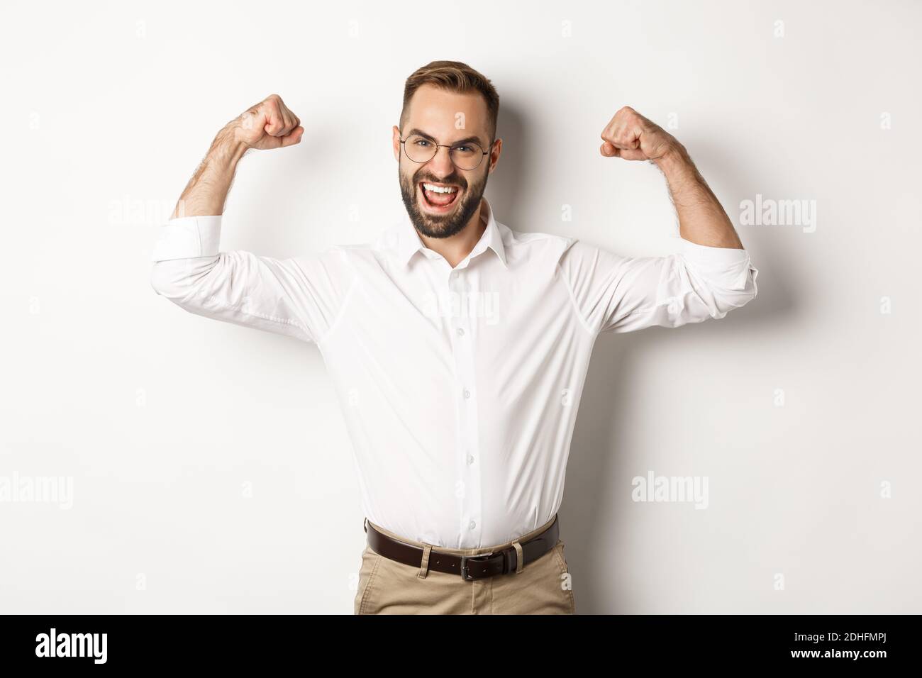 Successful manager flex biceps, showing muscles and looking confident ...