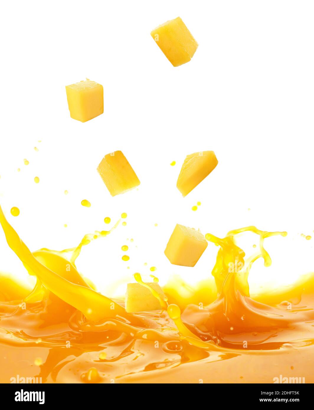 Pieces of fresh mango falling into juice on white background Stock ...