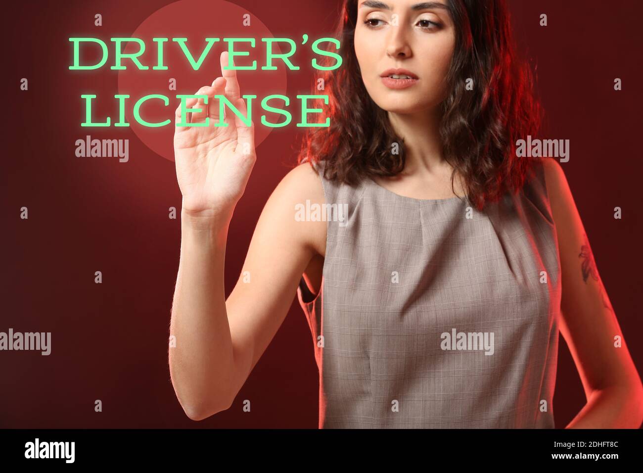Young woman touching text DRIVER'S LICENSE on virtual screen against ...