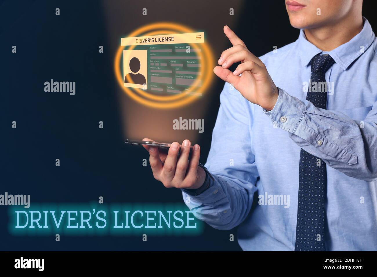 Young businessman with mobile phone touching driver's license on ...