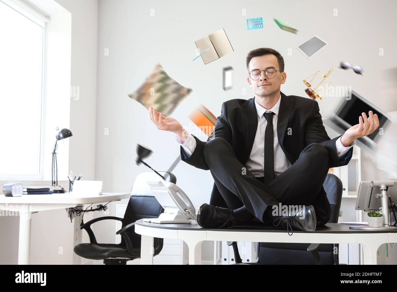 Different things flying around handsome meditating businessman in ...