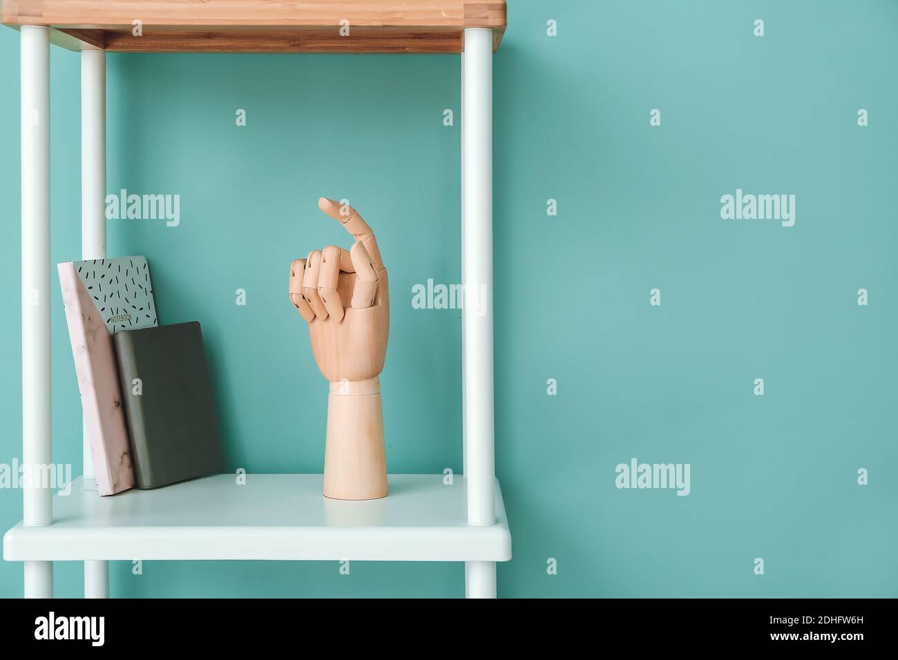 Wooden hand with notebooks on shelving Stock Photo - Alamy