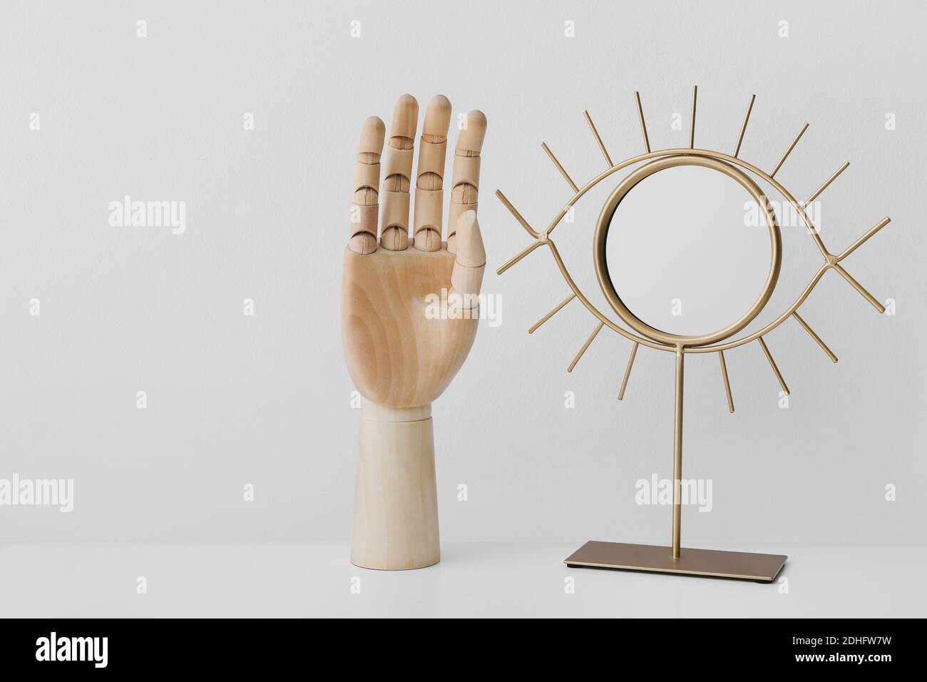 Wooden hand with mirror on light background Stock Photo - Alamy