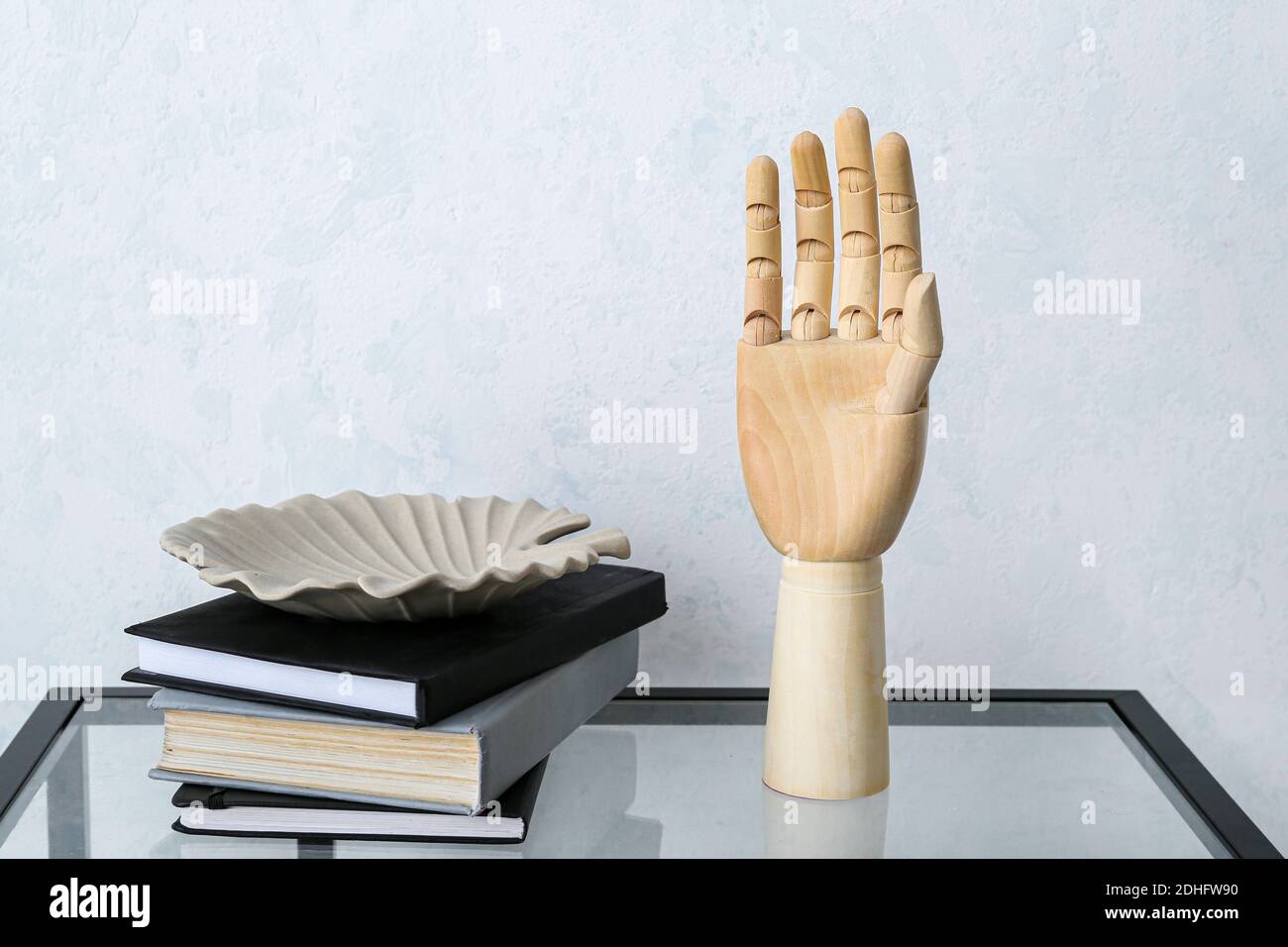 Wooden hand with notebooks on glass table Stock Photo - Alamy