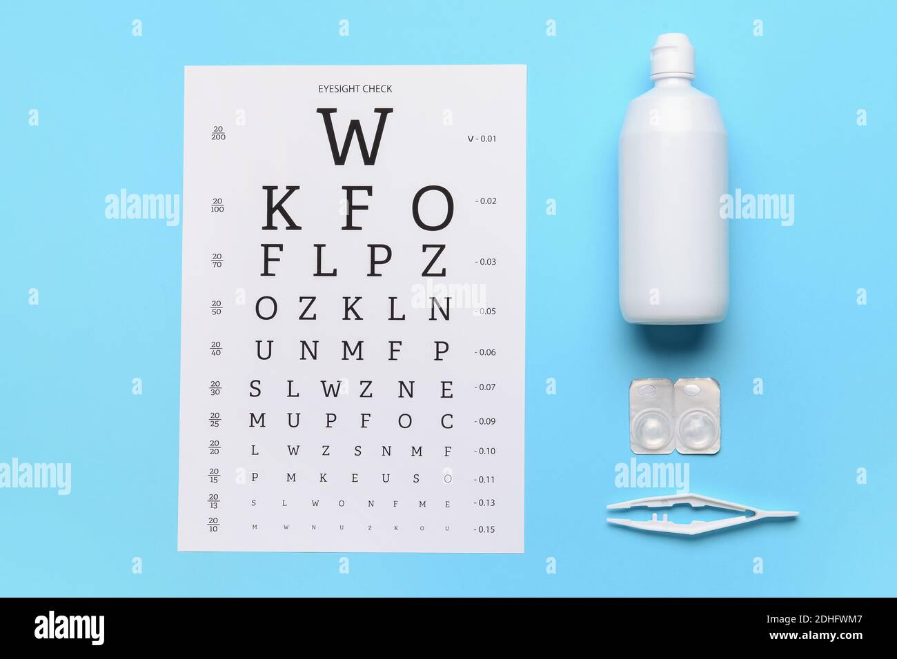 Contact lenses, tweezers, solution and eye test chart on color ...