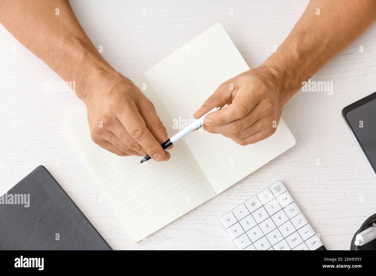 Man writing in notebook with pen Stock Photo - Alamy